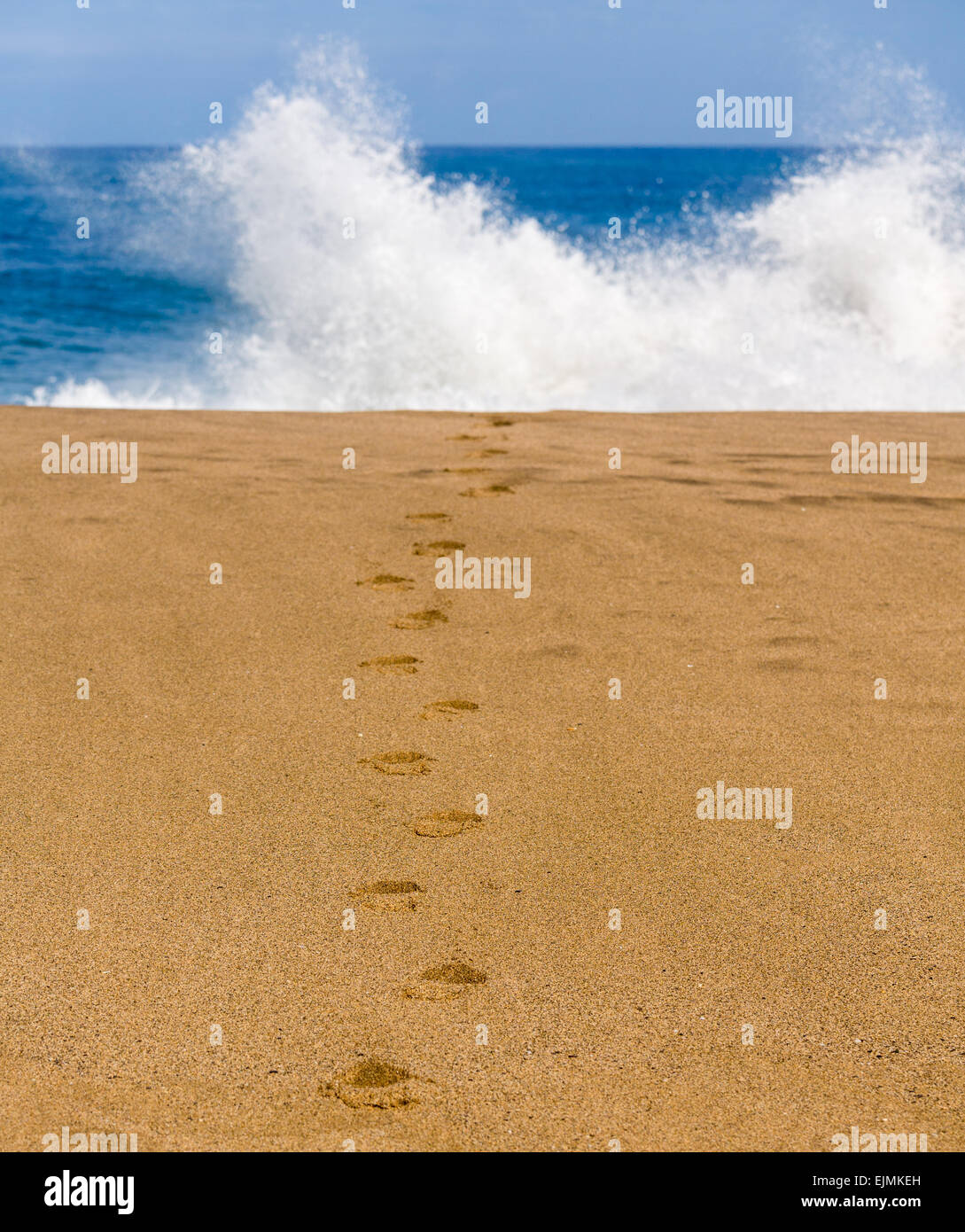 Smooth and sandy beach with footsteps leading one way towards the ...
