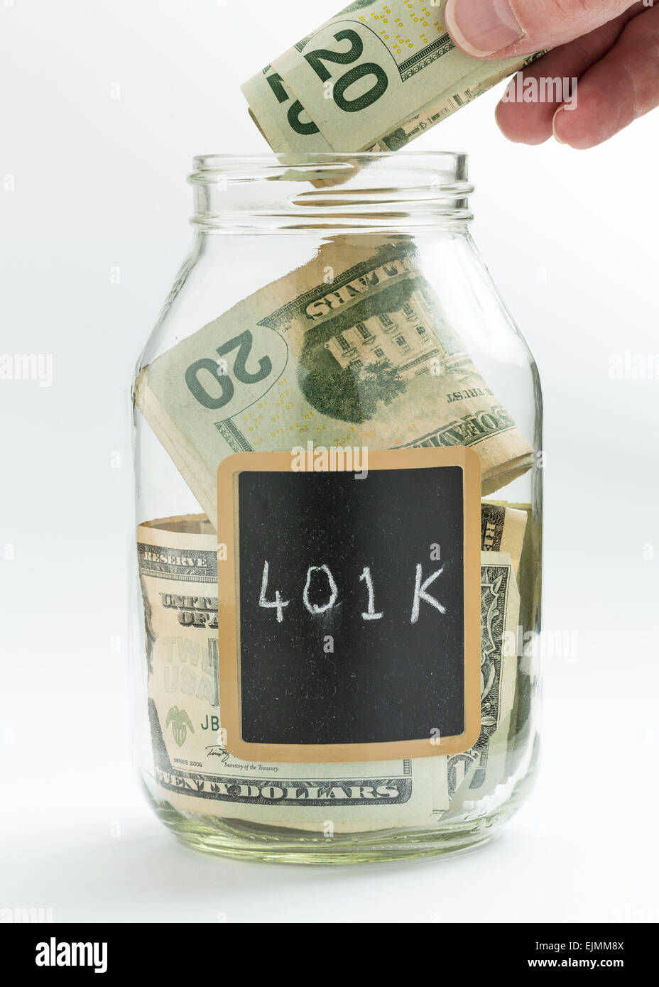 Caucasian hand putting money into glass jar on white background with ...