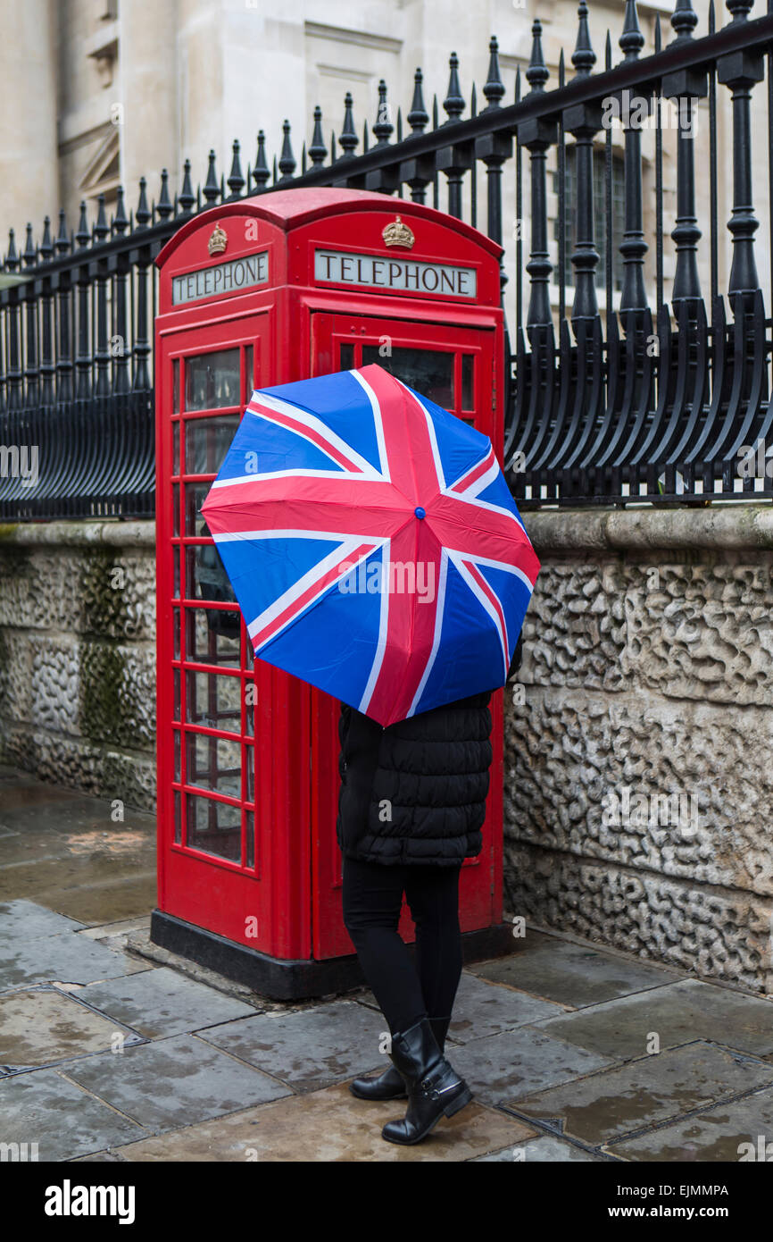 Woman with Union Jack umbrella, phone booth, London Stock Photo - Alamy