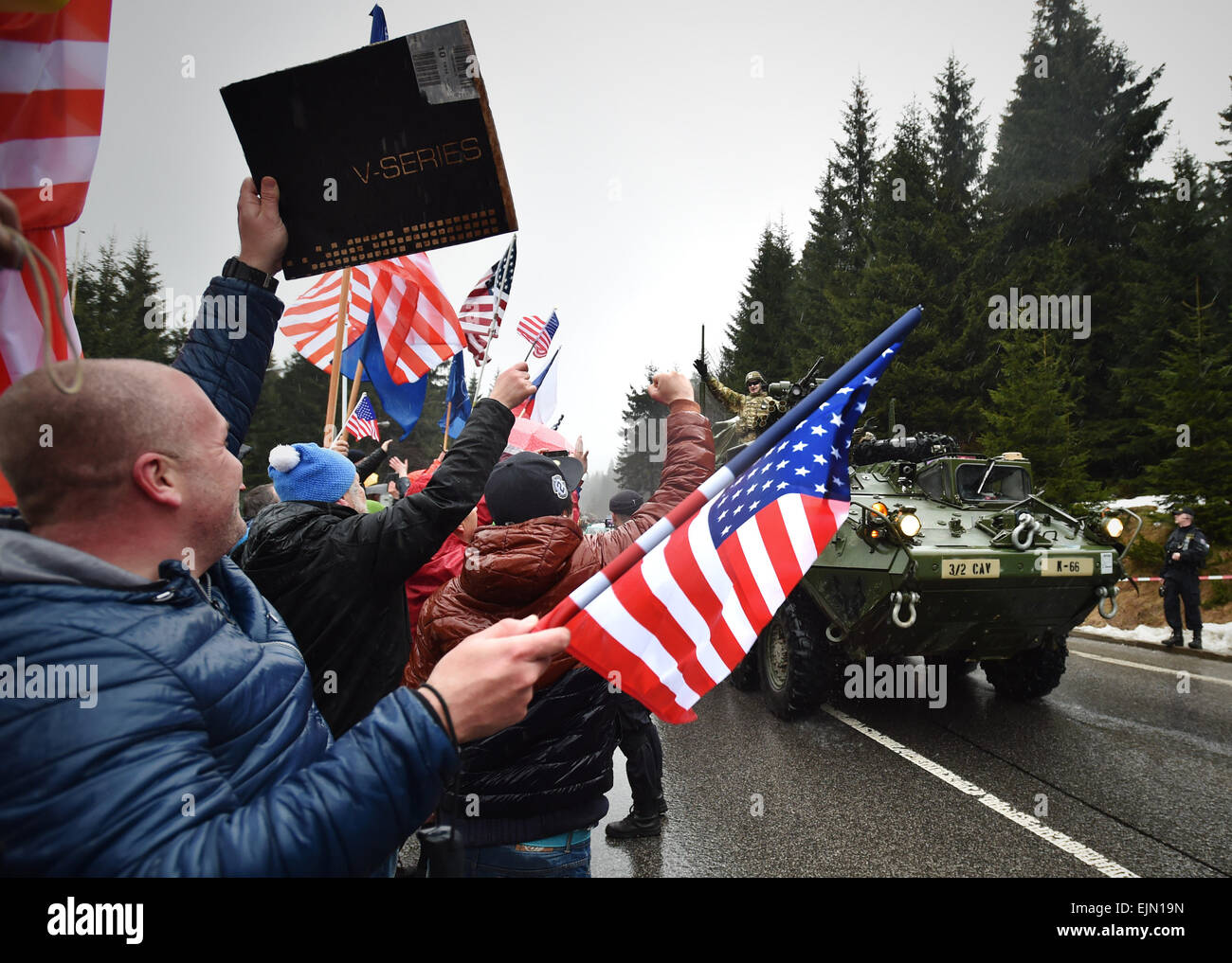 People with US flags welcome a group of US Army Stryker armored ...