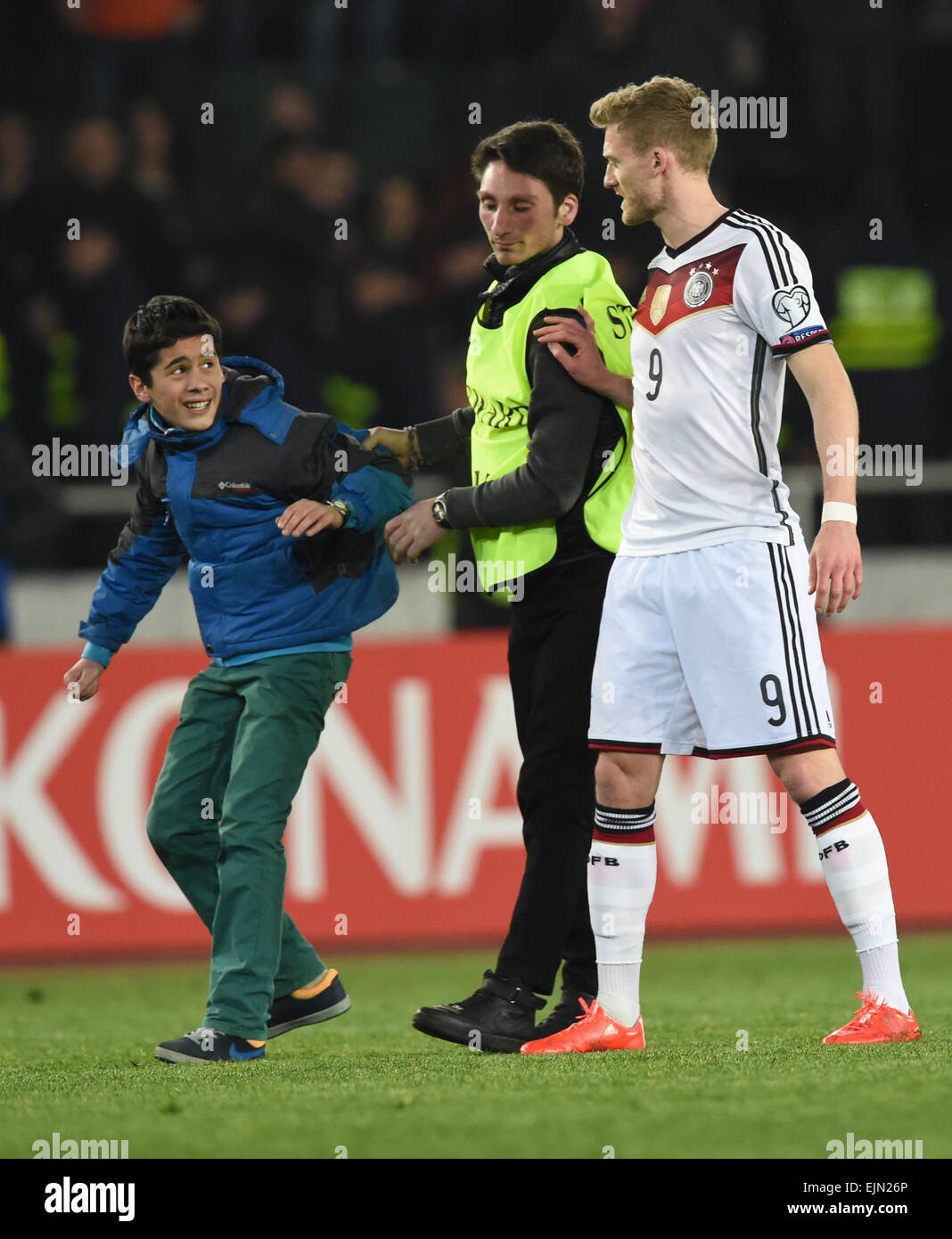 A young boy is caught by a steward next to Germany's Andre Schuerrle (R ...