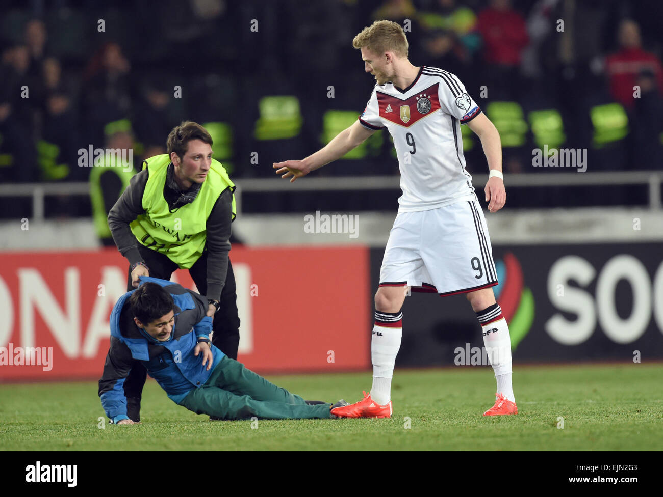 A pitch invader is caught by a steward next to Germany's Andre ...