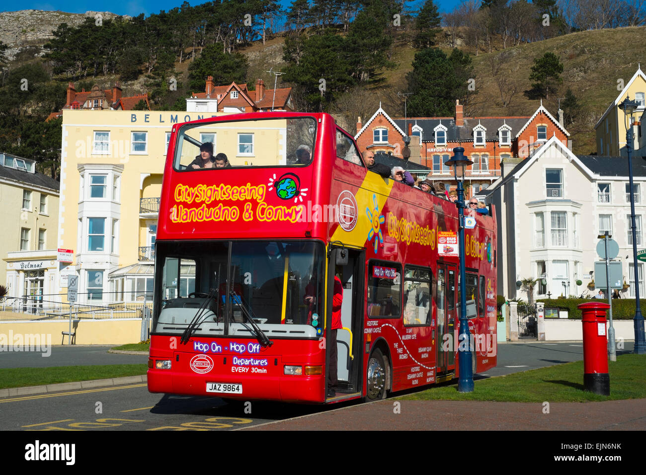 A red double decker sightseeing bus on the seafront under the Great ...