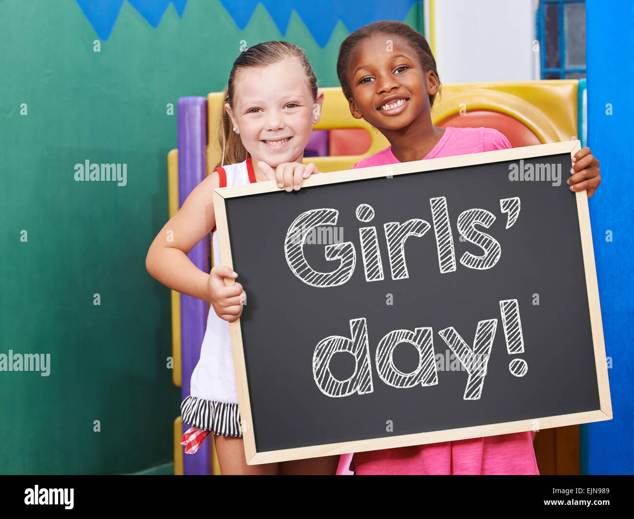 Two happy children holding a blackboard for the Girls' Day Stock Photo ...