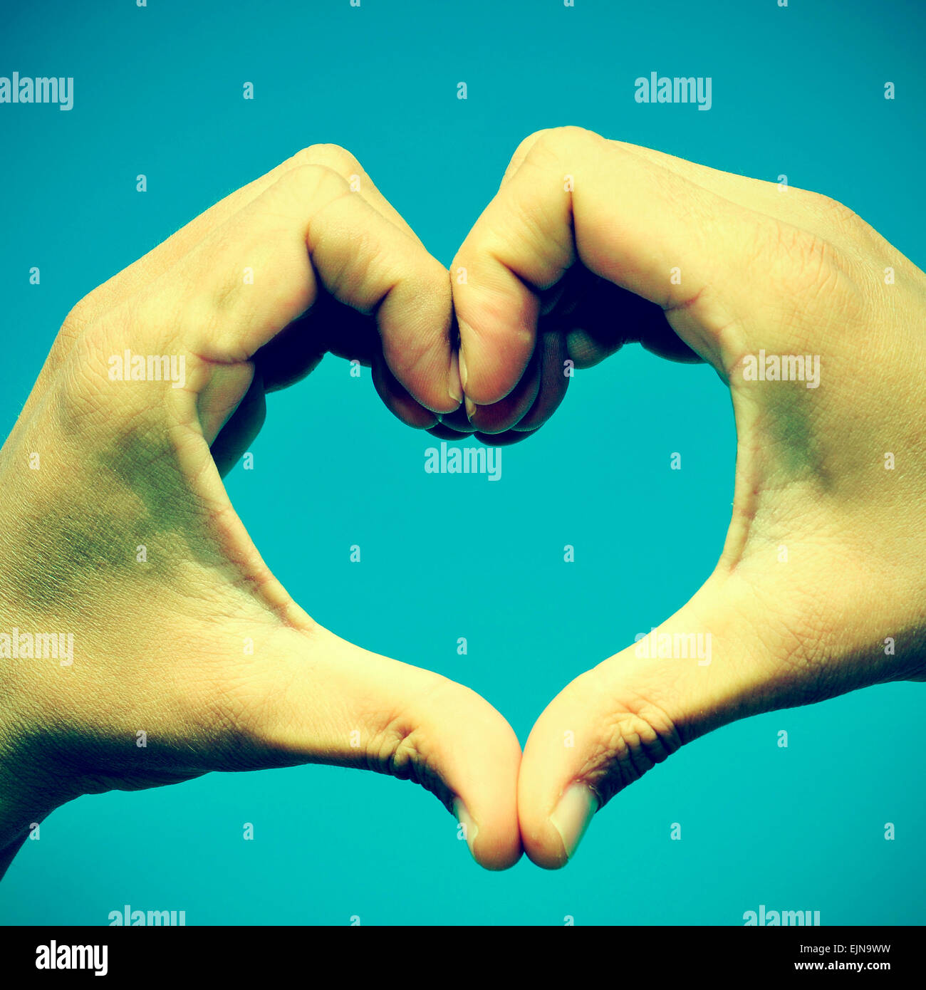 picture of man hands forming a heart over the blue sky, with a retro ...