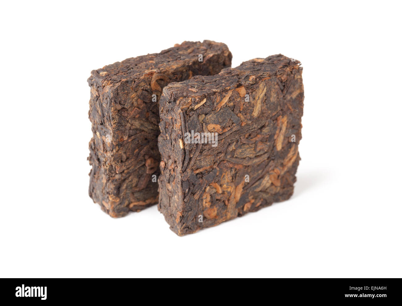 Two pressing briquette of black Chinese Shu Pu Erh tea stand isolated ...