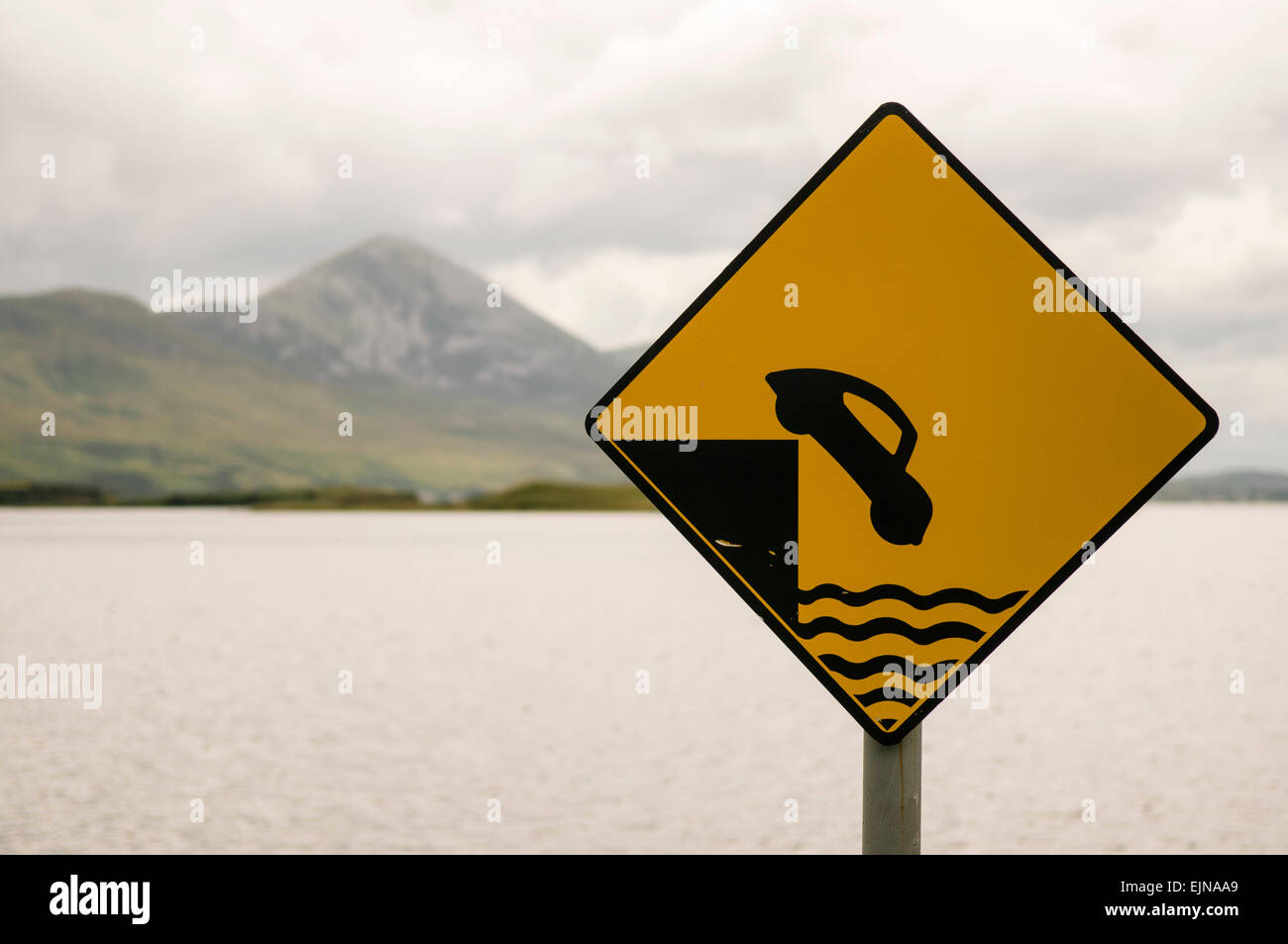 Yellow warning sign on the end of a pier warning drivers Stock Photo ...