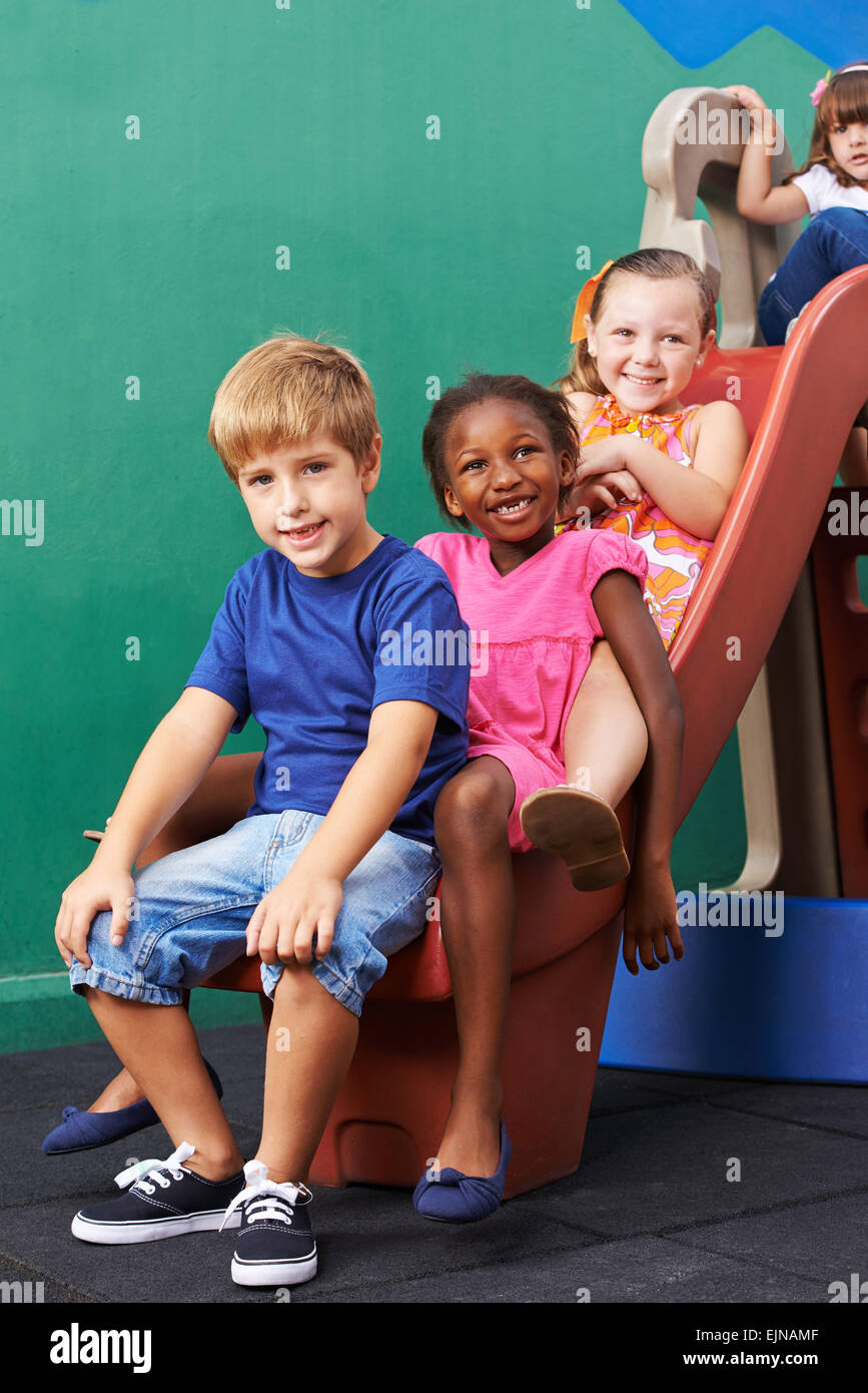 Happy group of kids playing on slide in preschool Stock Photo - Alamy