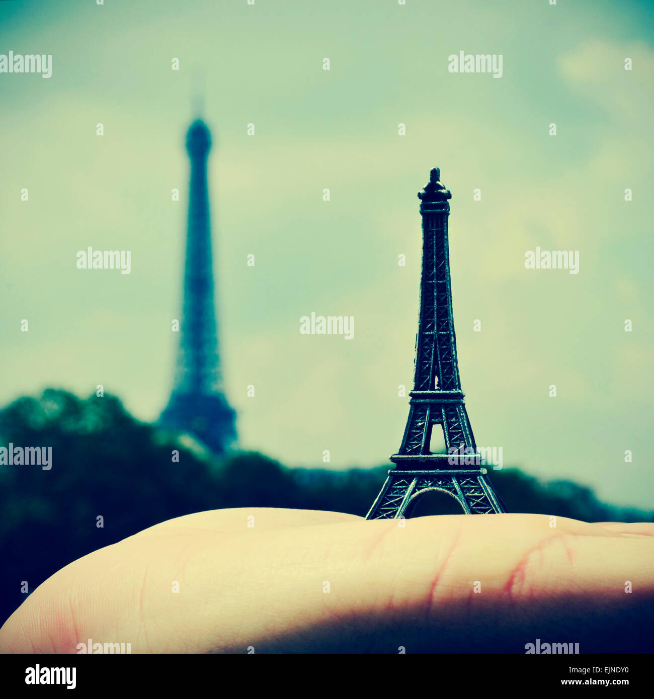 picture of someone holding a reproduction of the Eiffel Tower with the ...