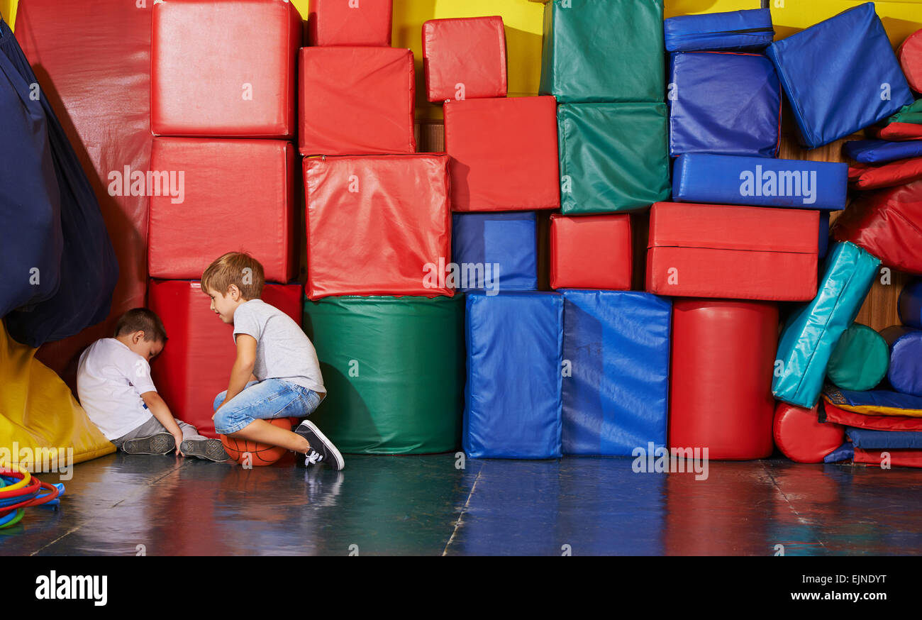 Sad child sitting in corner of gym and boy tries to comfort him Stock ...