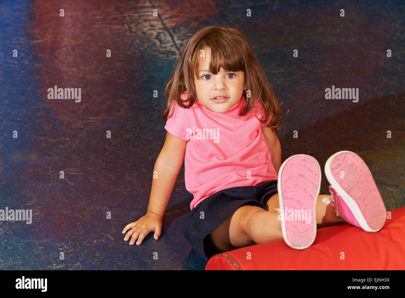 Little child doing children sports in gym with her legs on a pillow ...