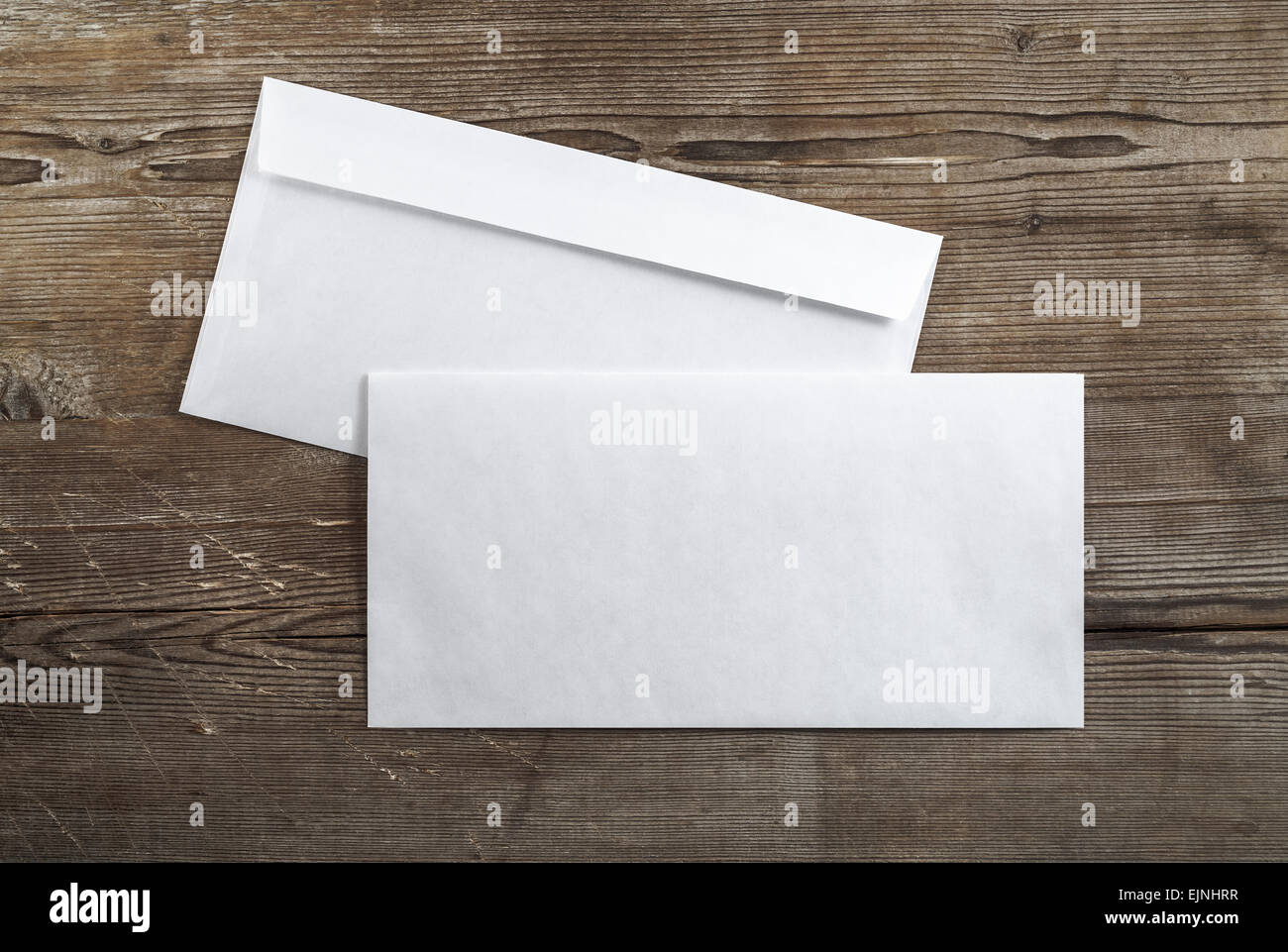Photo of blank envelopes on a dark wooden background. Back and front ...