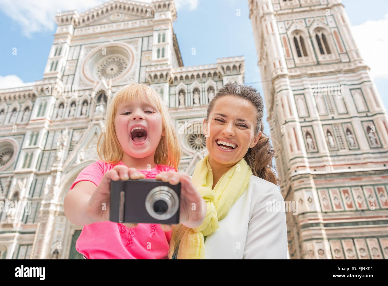 Happy mother and baby girl taking photo in front of duomo in florence ...