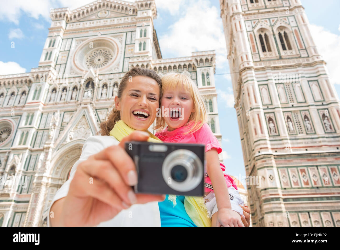 Happy mother and baby girl taking photo in front of duomo in florence ...
