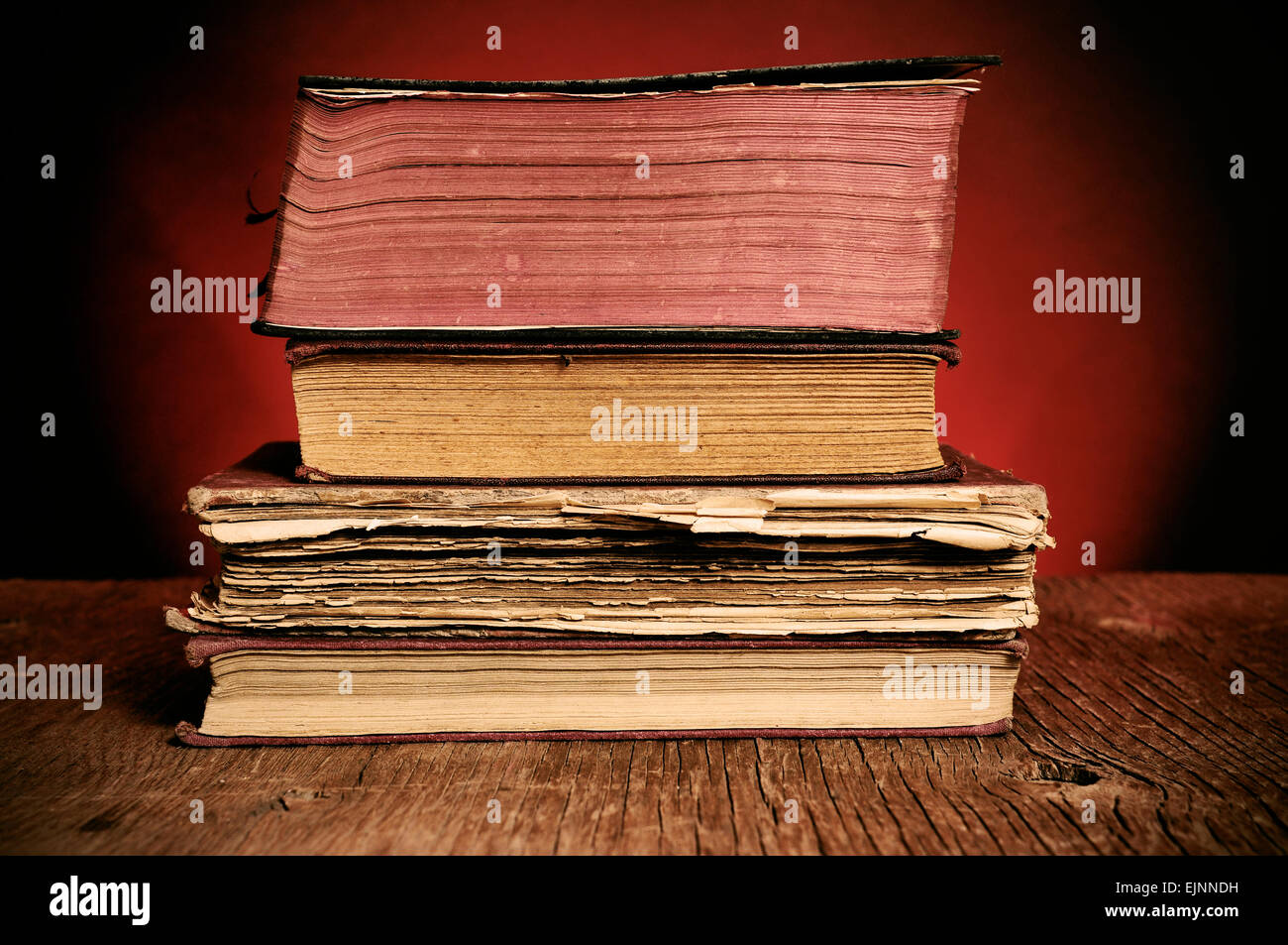 a pile of worn-out old books on a rustic wooden table Stock Photo - Alamy