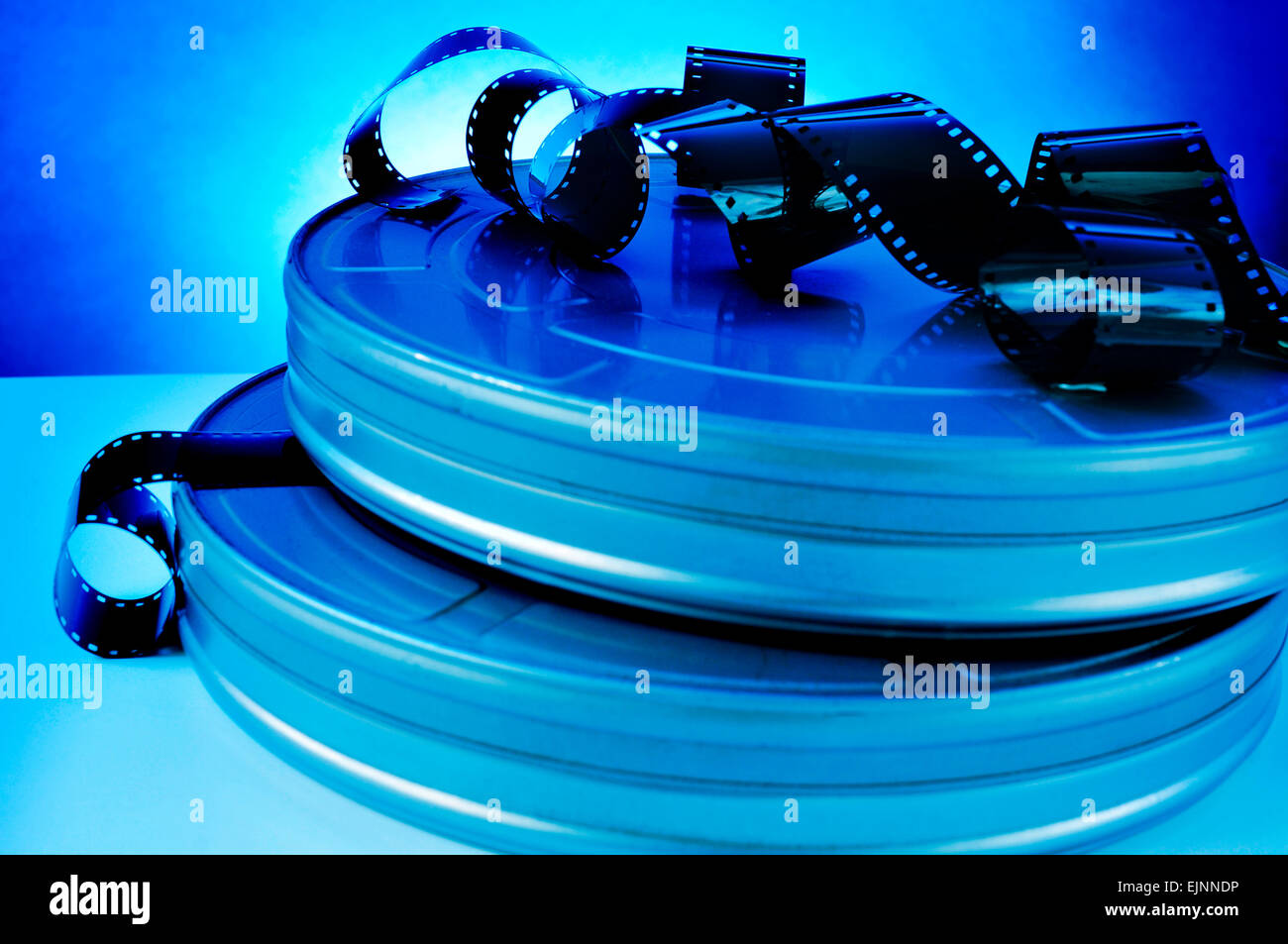 some film strips and metal movie film reel canisters on a table with a ...