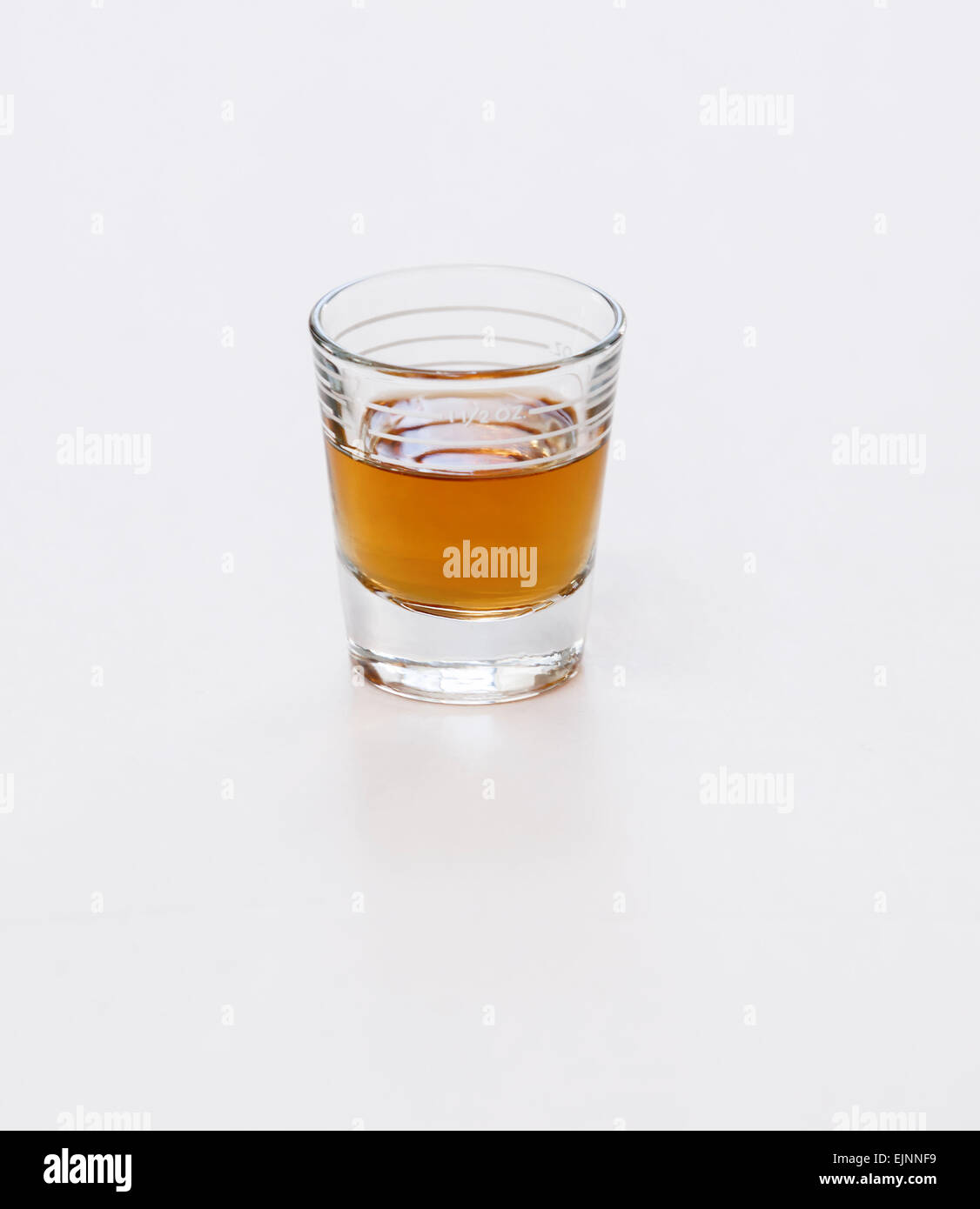 One full shot glass of alcohol on a white background Stock Photo - Alamy