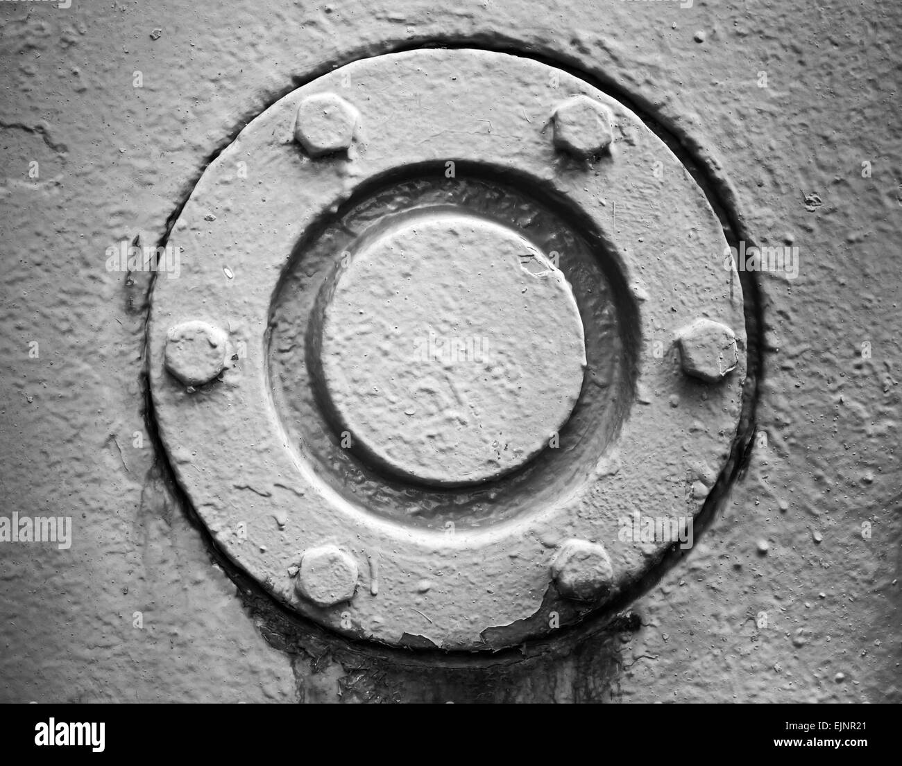 Round gray cover mounted with bolts, abstract old industrial detail ...