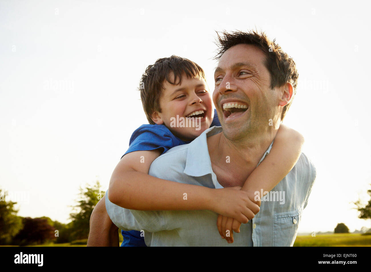 A father giving his son a piggyback Stock Photo - Alamy