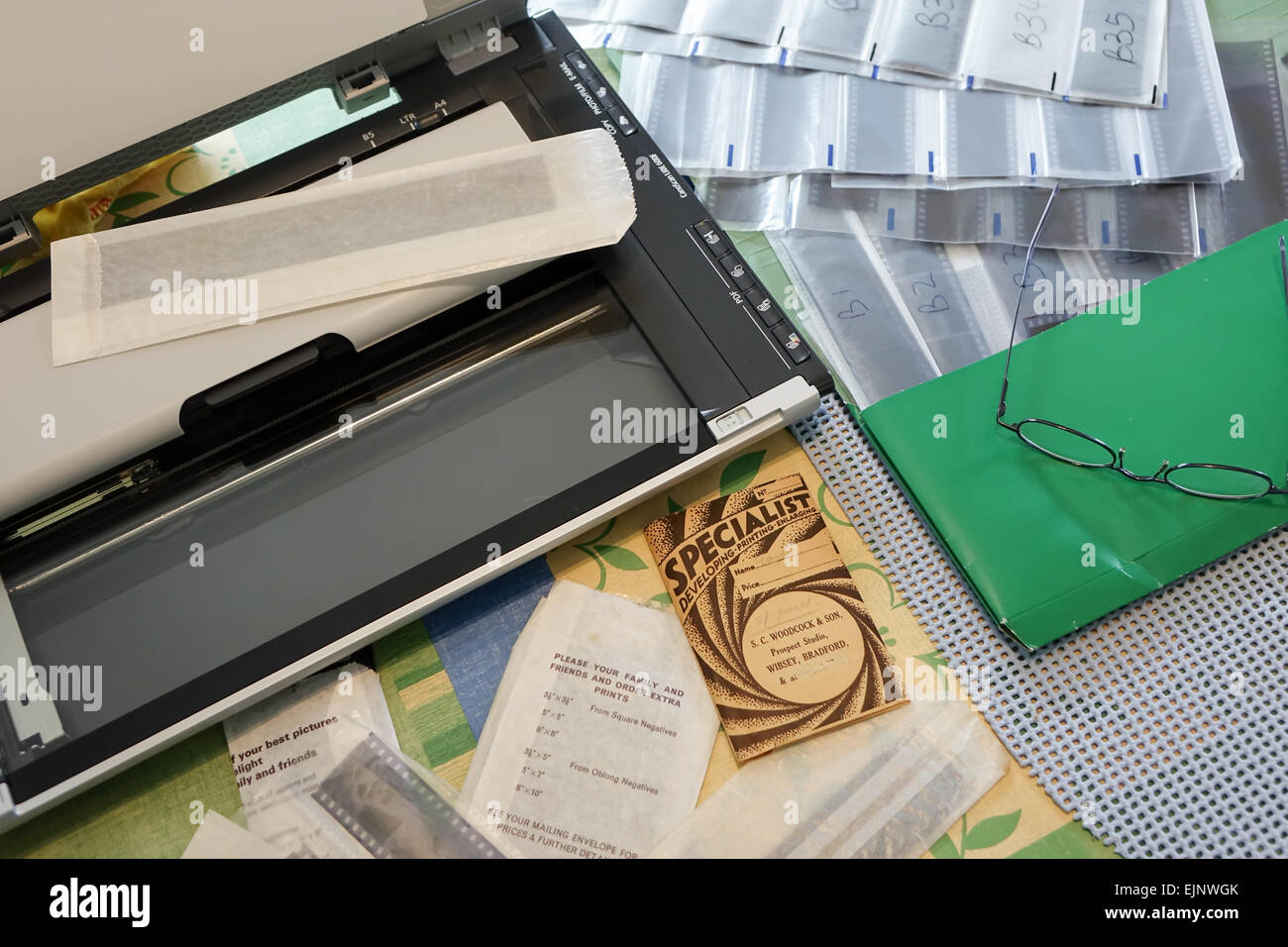 Laptop film scanner and negatives on a table being scanned and ...