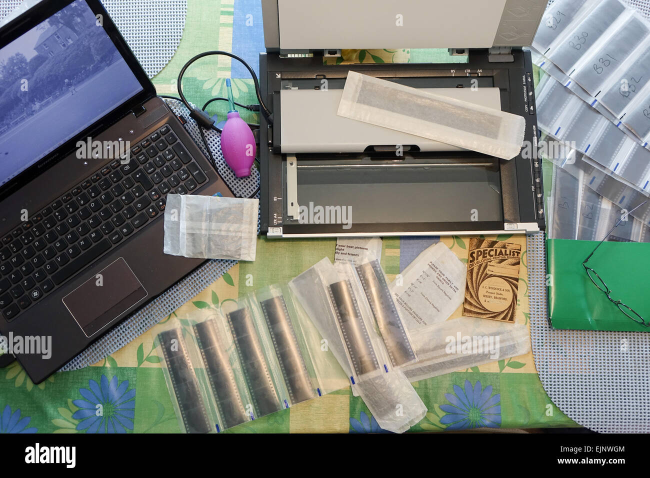 Laptop film scanner and negatives on a table being scanned and ...