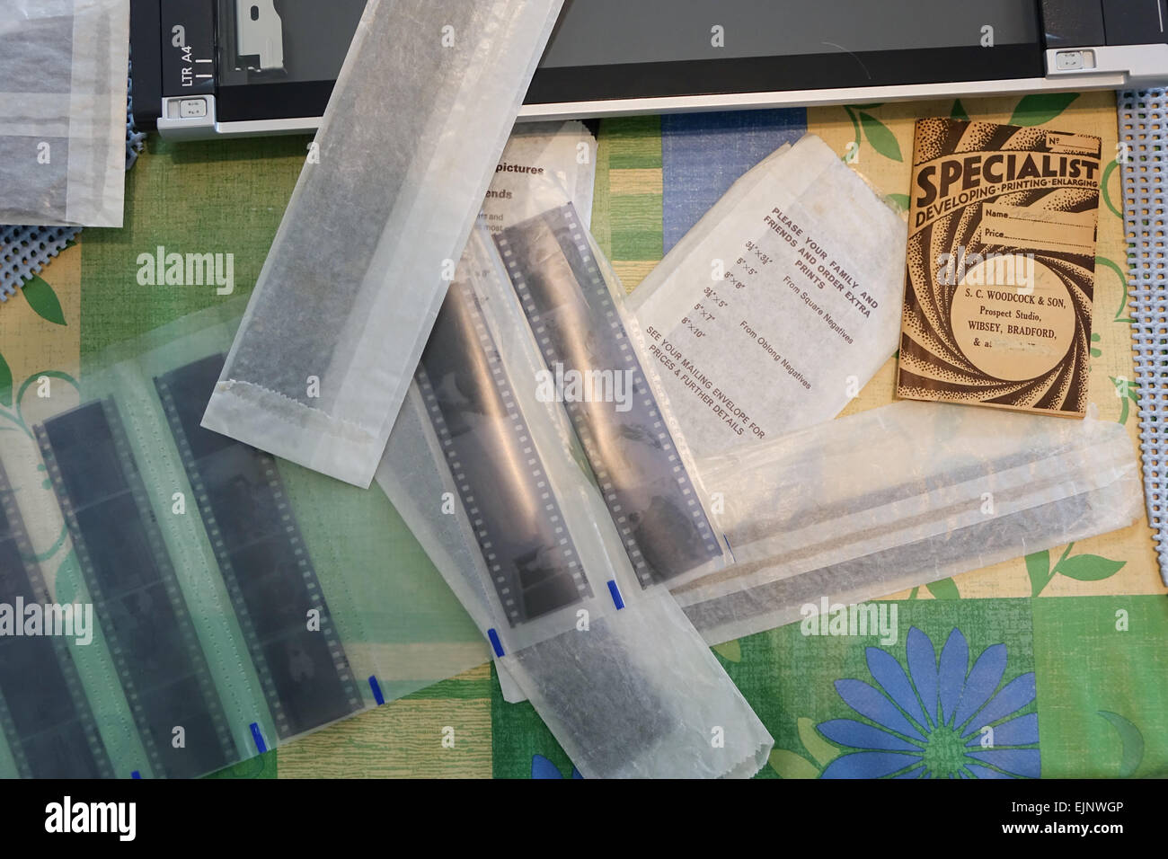 Laptop film scanner and negatives on a table being scanned and ...