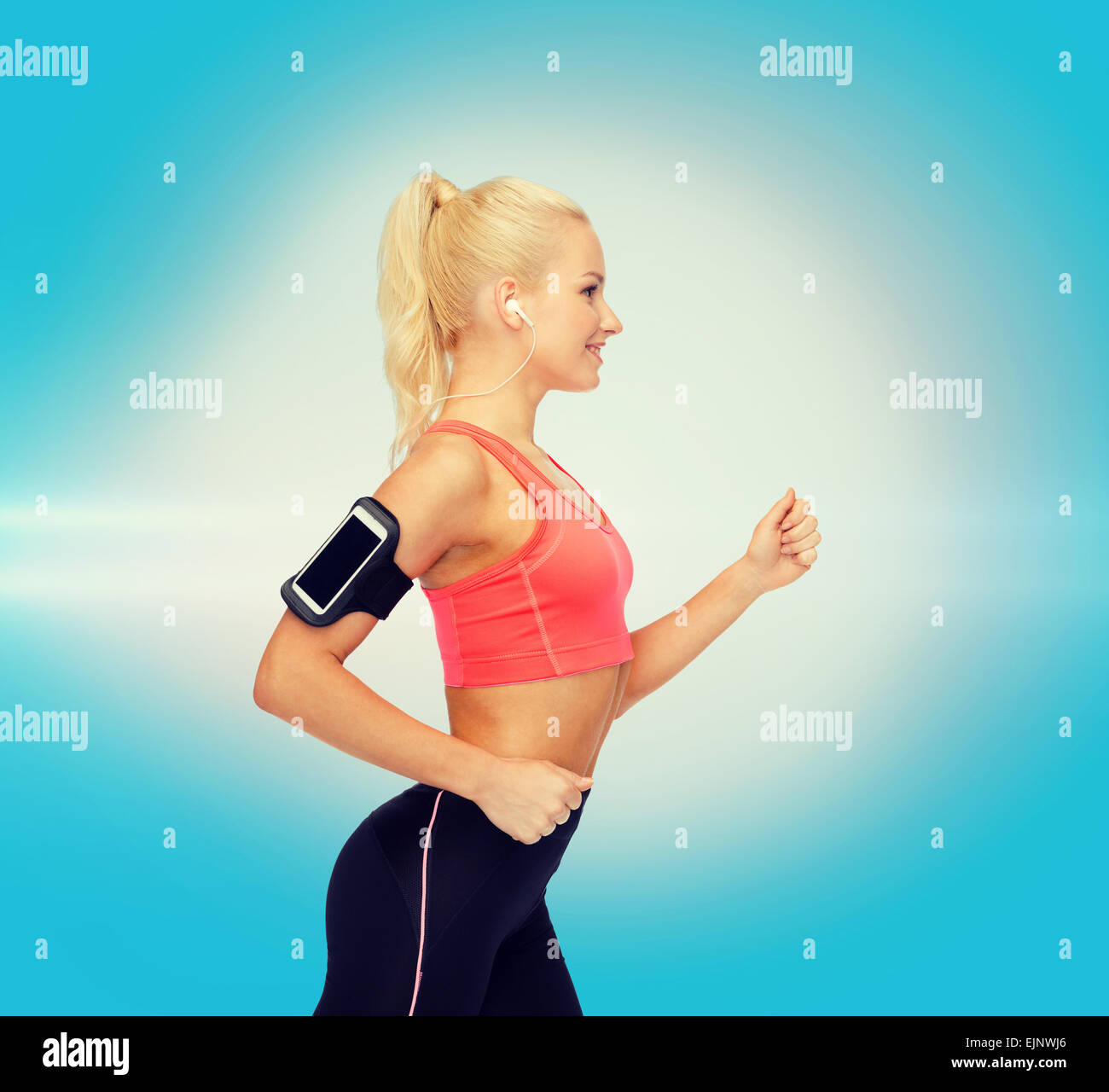 sporty woman running with smartphone and earphones Stock Photo - Alamy