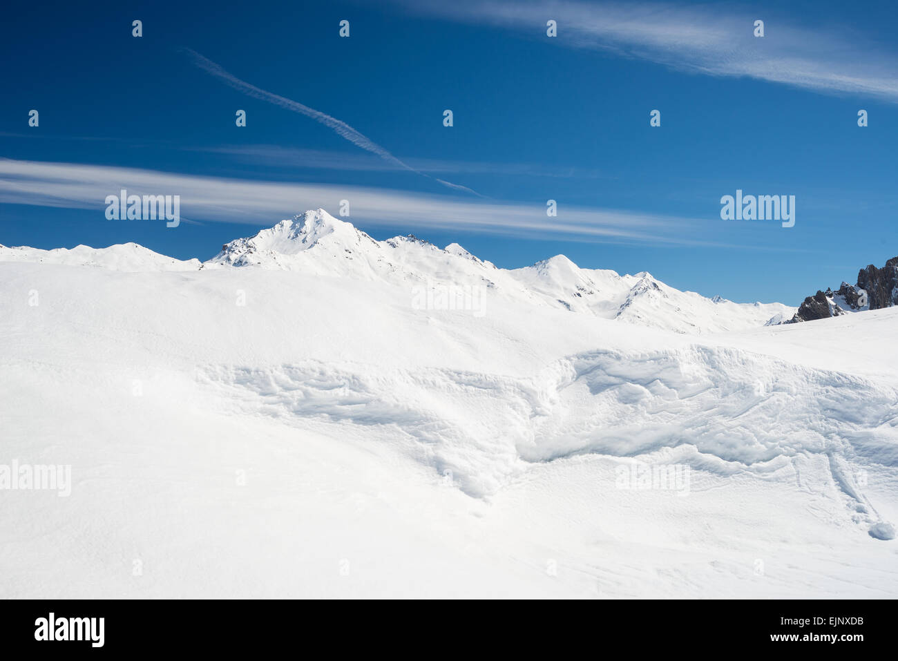 Snowy slope shaped by the wind with snowdrift on the ridge and majestic ...
