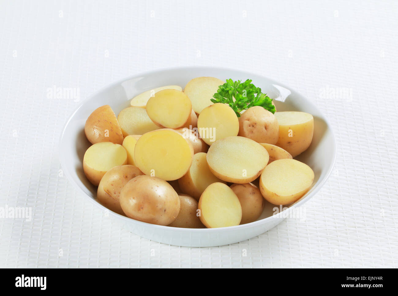 Halved unpeeled potatoes in a porcelain dish Stock Photo - Alamy