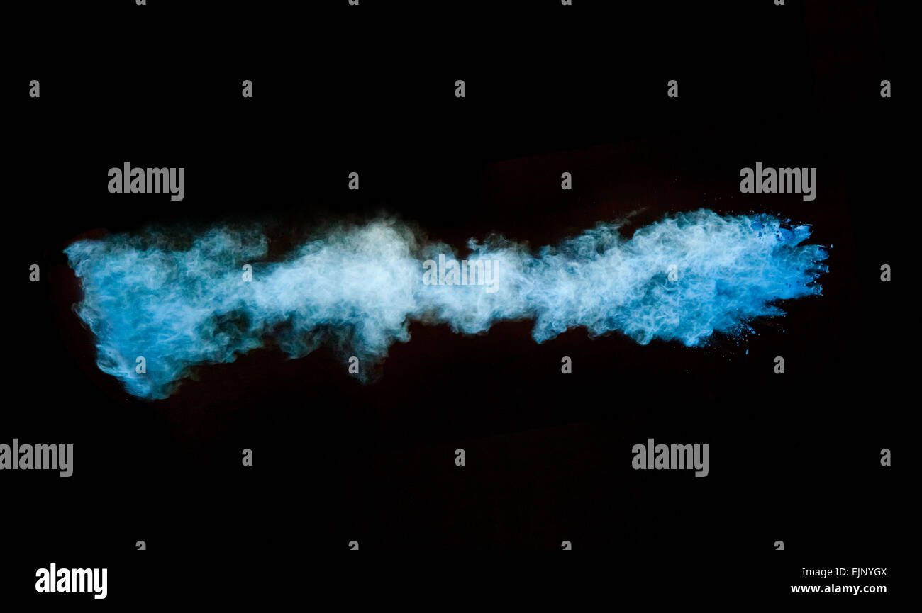 Freeze motion of blue dust explosion isolated on black background Stock ...