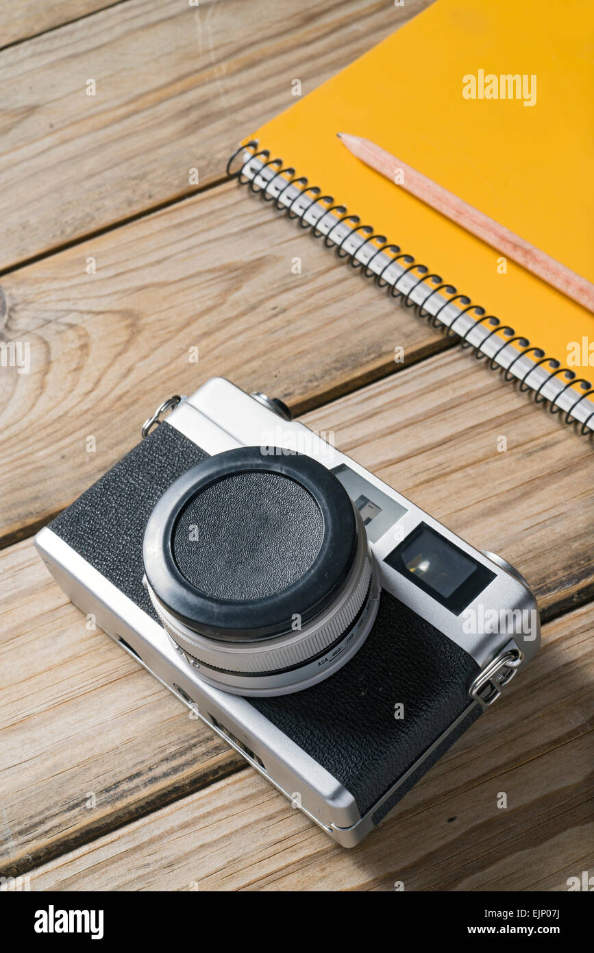 analog photographic camera and notebook over wooden surface Stock Photo ...