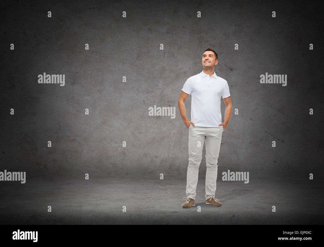 smiling man with hands in pockets looking up Stock Photo - Alamy