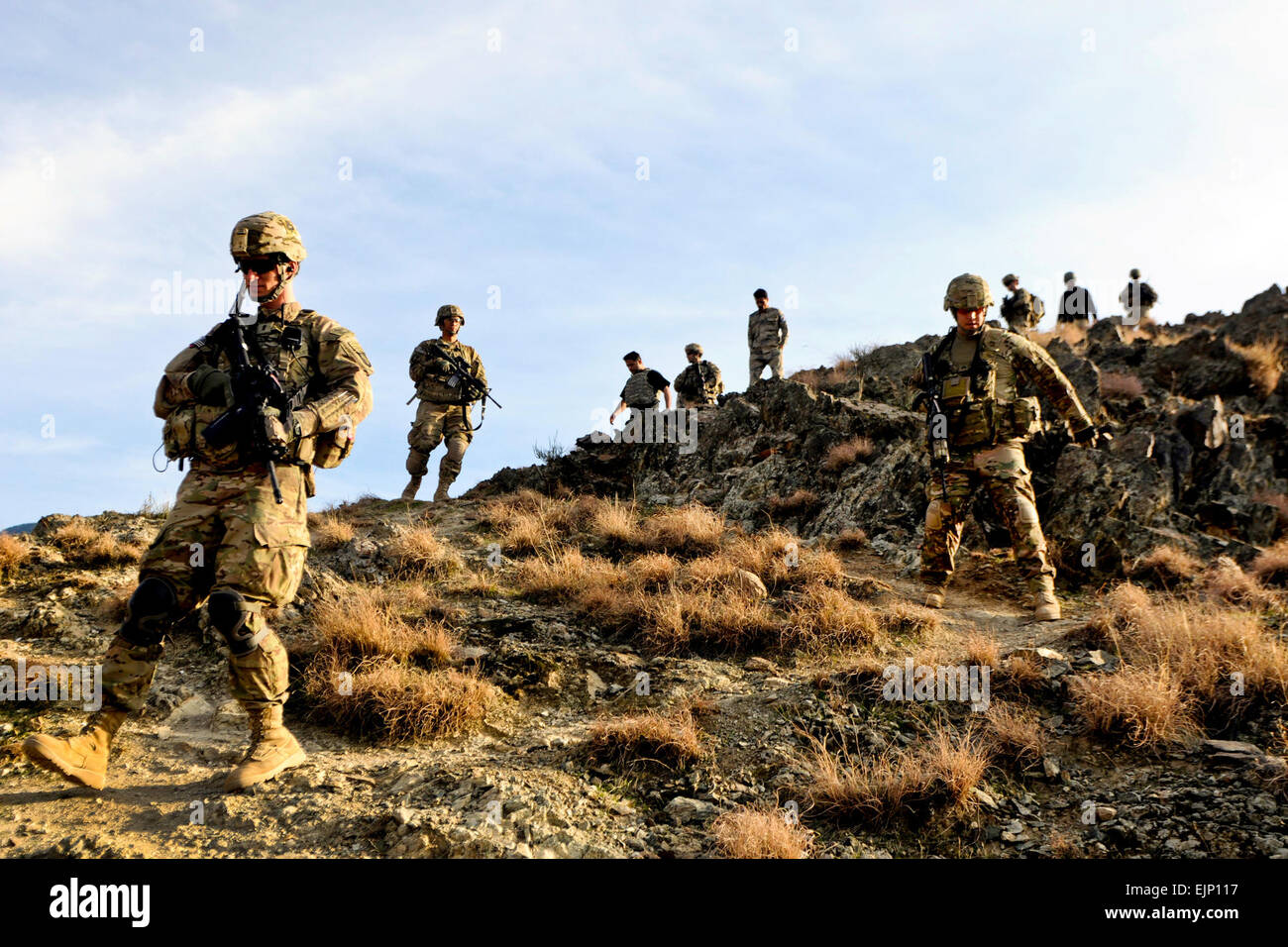 U.S. soldiers patrol down a mountain after visiting an Afghan border ...