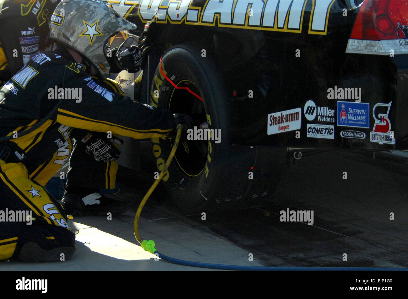 A crewmember of the U.S. Army sponsored number eight car performs a ...
