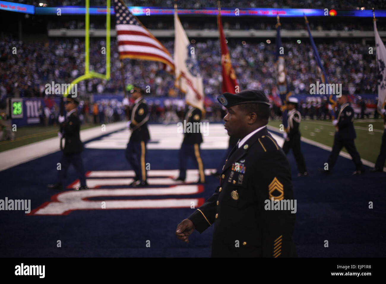 A joint service color guard marches off the field along with Marines ...