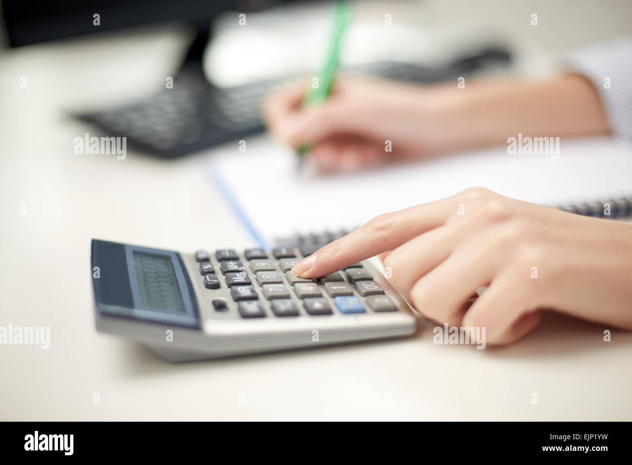 close up of woman with calculator taking notes Stock Photo - Alamy