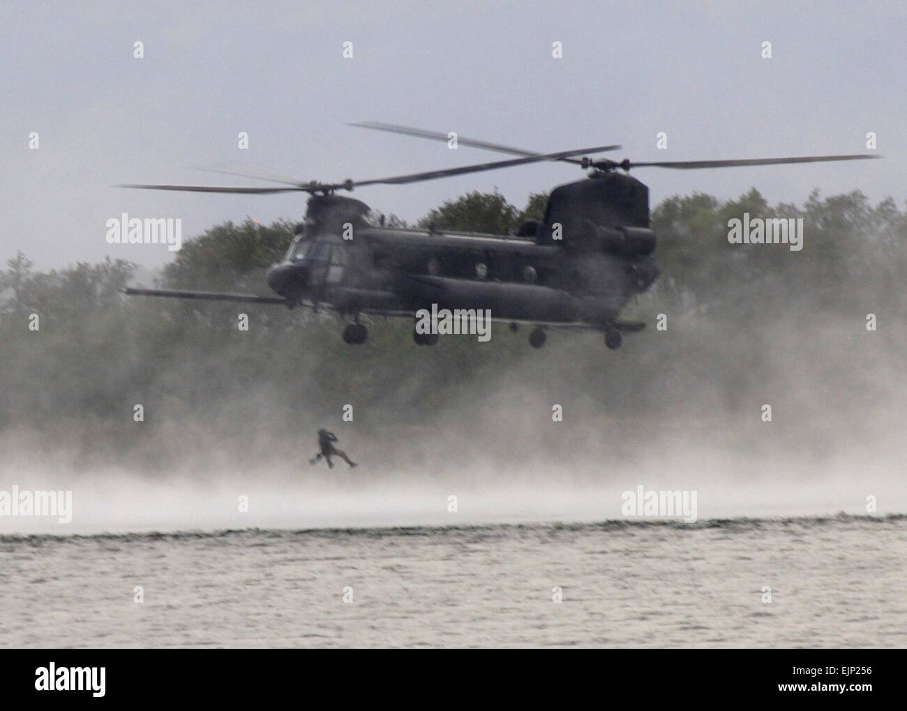 An U.S. Air Force Airman is hoisted from the water by an MH-47 Chinook ...