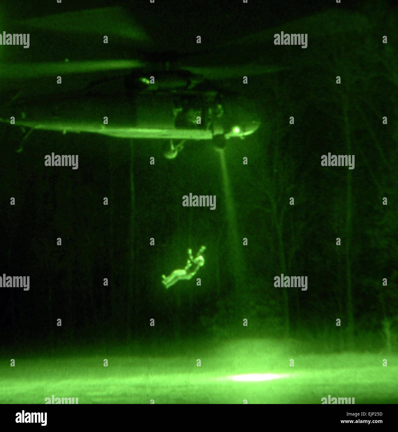 A emergency rescue worker is lowered from a UH-60 Black Hawk helicopter ...