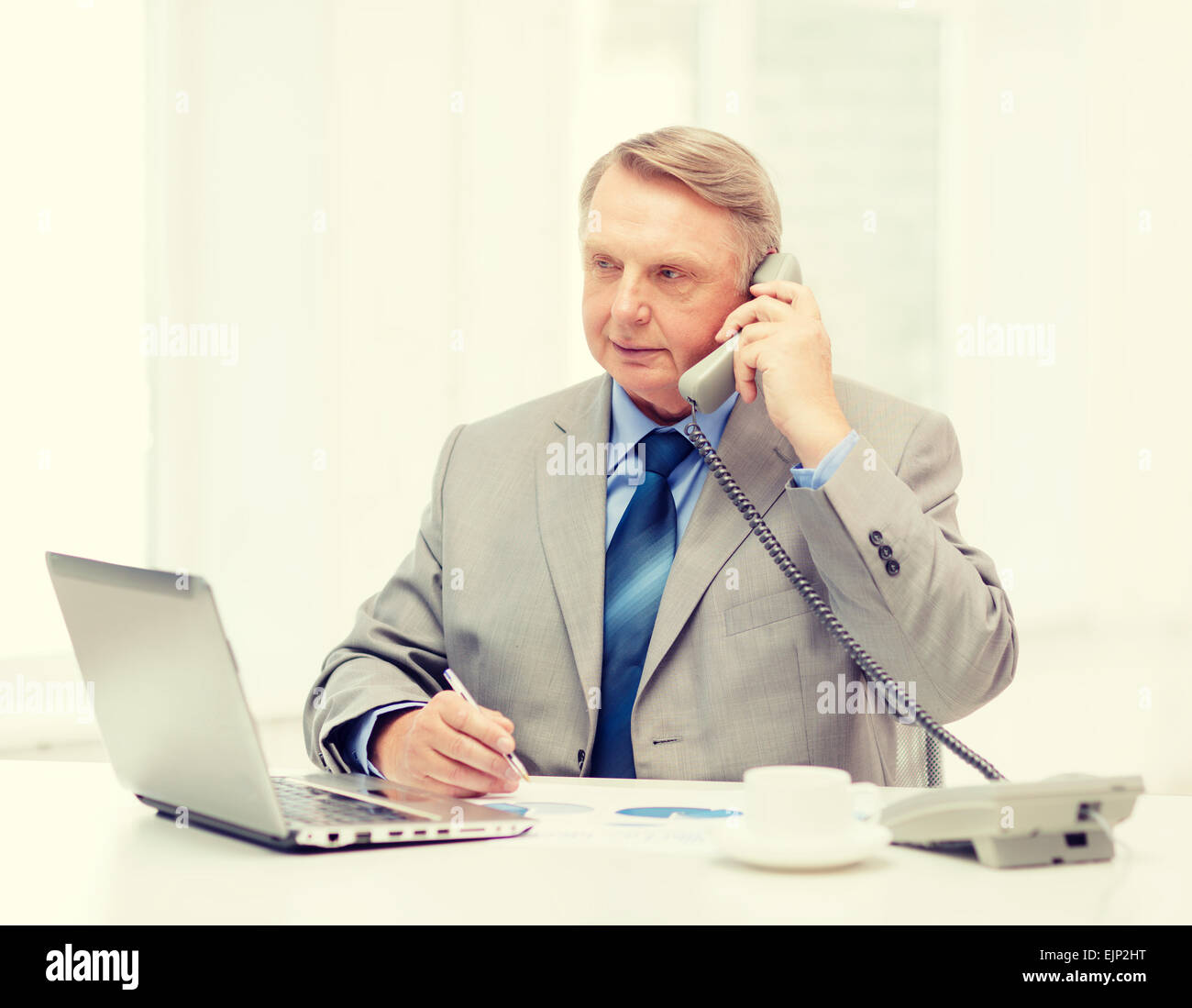 busy older businessman with laptop and telephone Stock Photo - Alamy