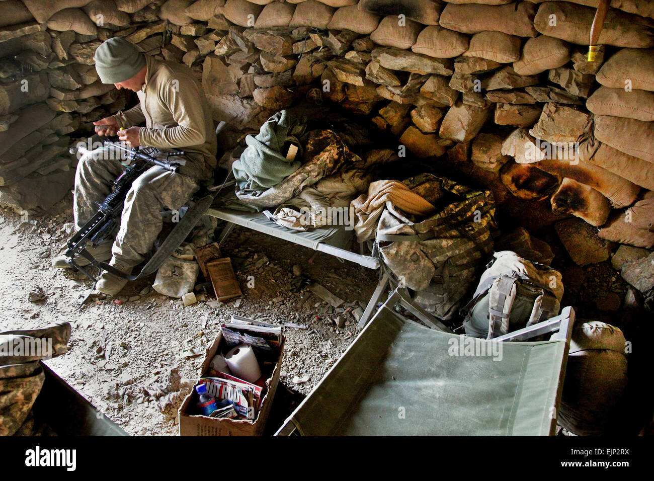 U.S. Army Pfc. Stephen Martin cleans his weapon inside a small shelter ...