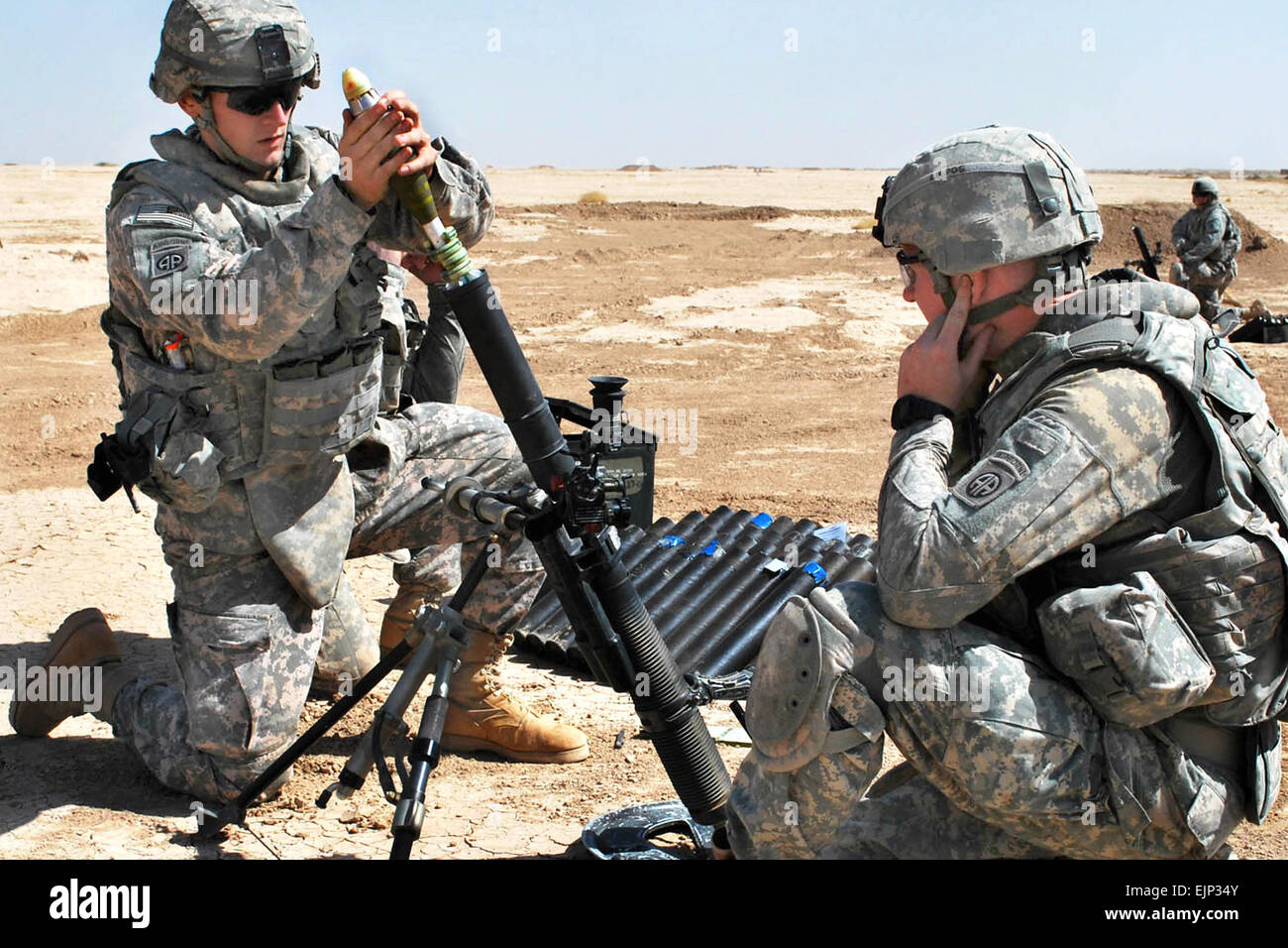 U.S. Army Pfc. Gregory Conway, left, prepares to drop a mortar into the ...