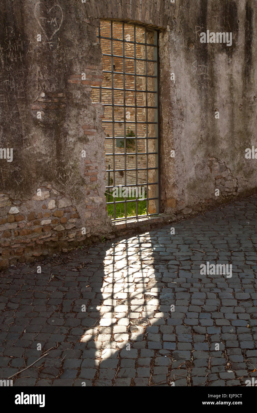 Metal lattice in old wall and its sun pattern on a ground Stock Photo ...