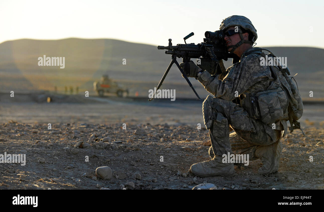 Spc. Christopher Keefe pulls security on a hilltop while mechanics look ...
