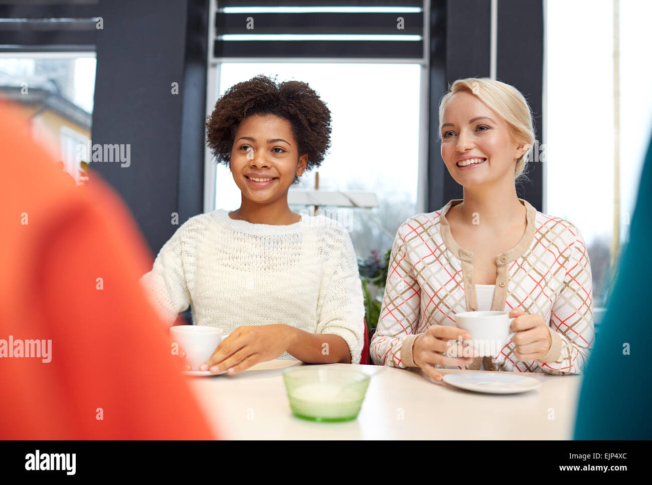 happy young women drinking tea or coffee at cafe Stock Photo - Alamy