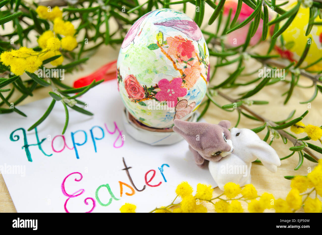 Hand painted decoupage Easter egg on wooden surface with a Happy Easter ...