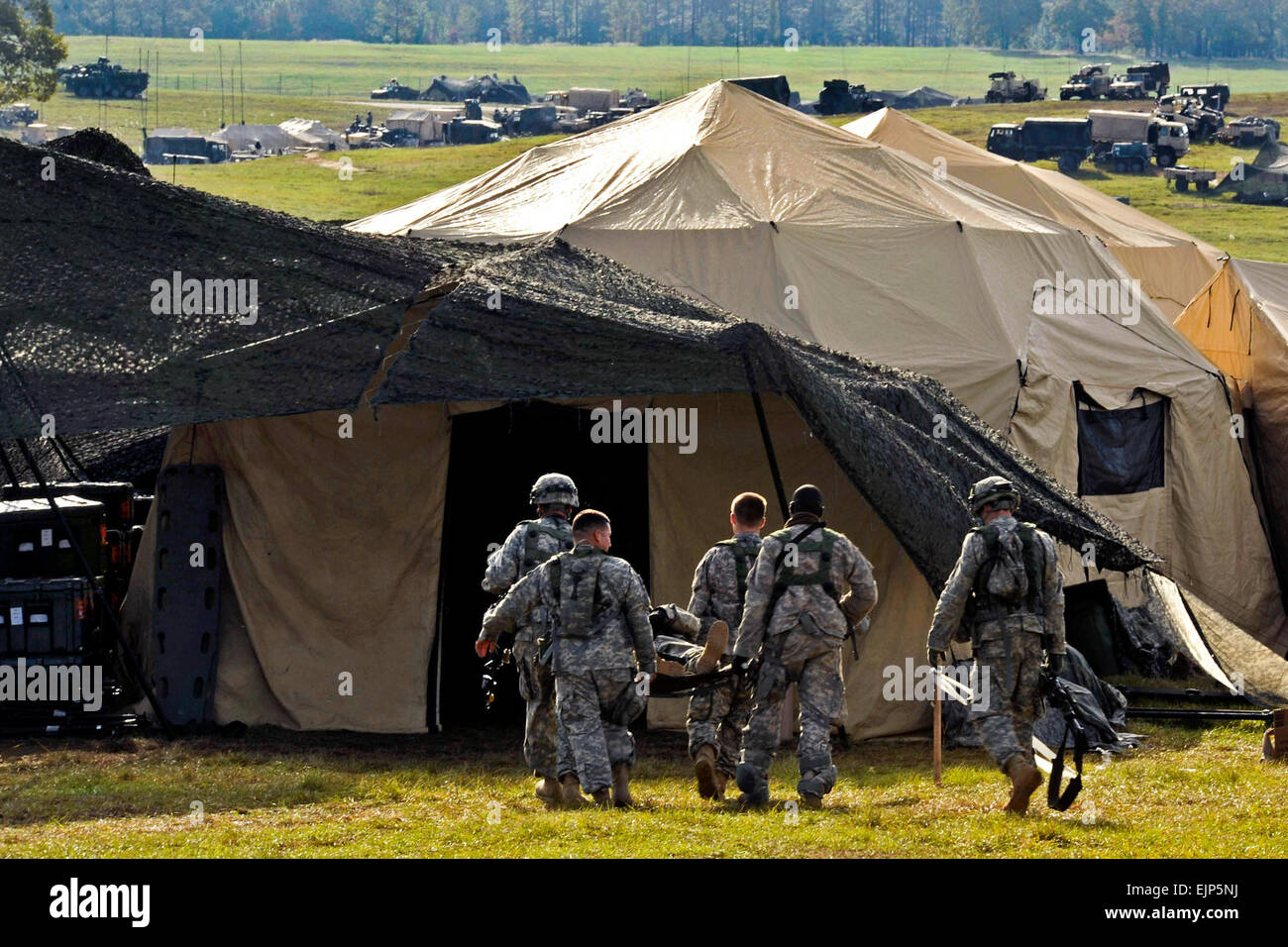 U.S. Army Soldiers litter transport a simulated injured patient to the ...