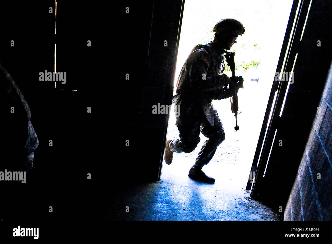 Spc. Greg Hadley, 164th Military Police Company﻿, enters a building ...