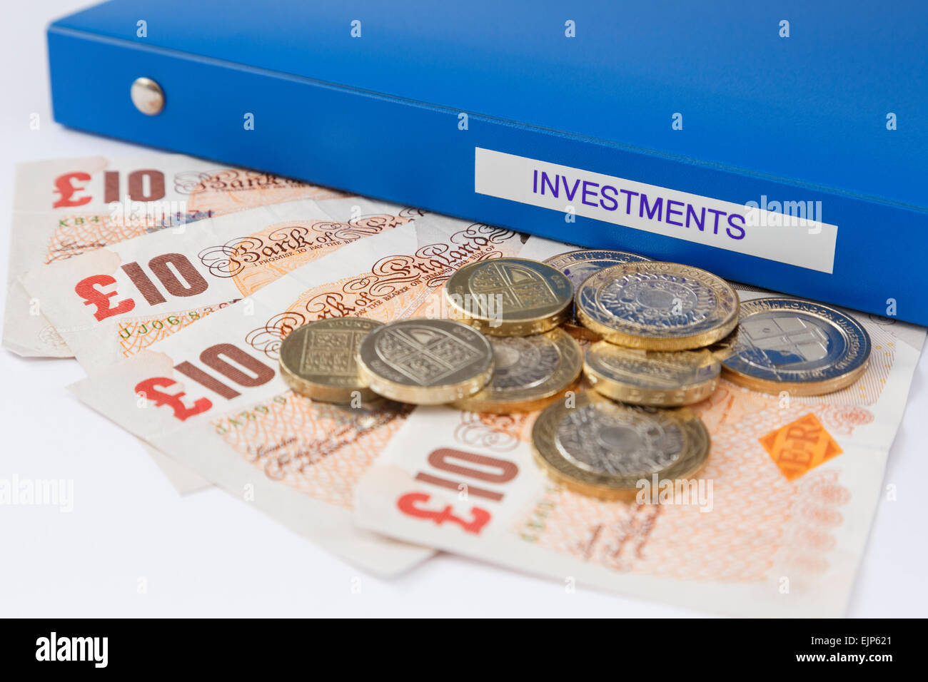 Investments portfolio folder with sterling ten pound notes and £ coins ...