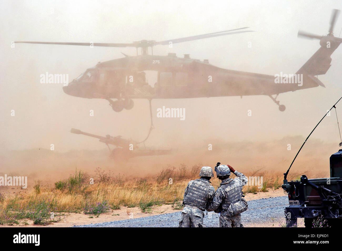 Soldiers stay clear of the sand and rotor wash after hooking their 105 ...