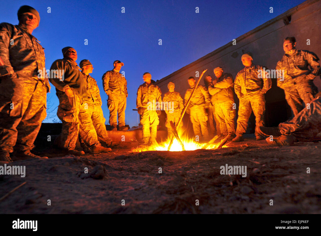 U.S. Army Soldiers gather around a fire to stay warm during an ...